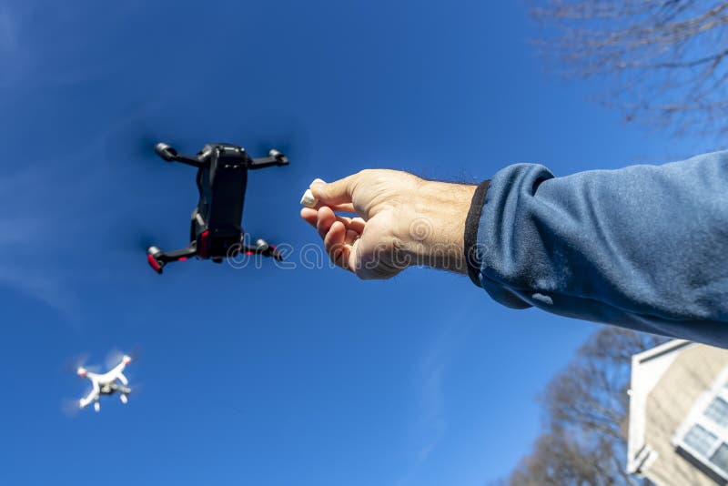 A Group of Drones Fly Together through the Air Against a Blue Sky Stock ...