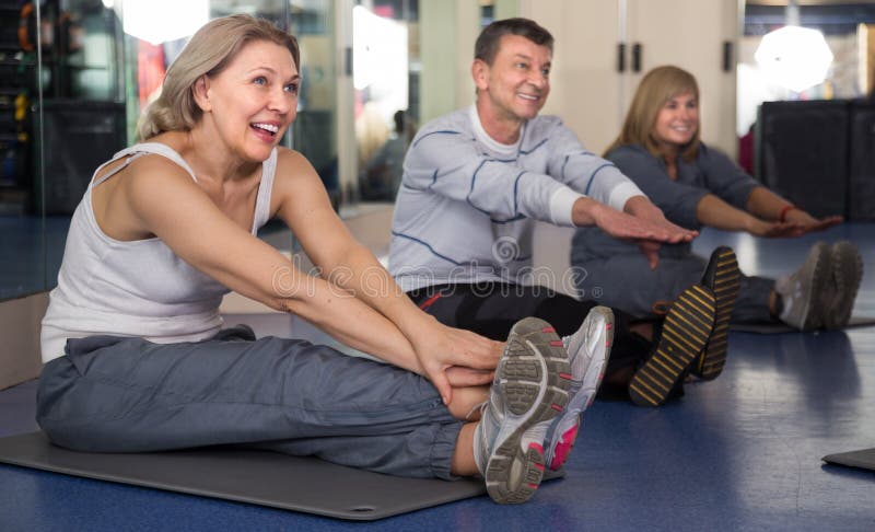 Elderly People Doing Exercise on Mat in Modern Gym Stock Image - Image ...
