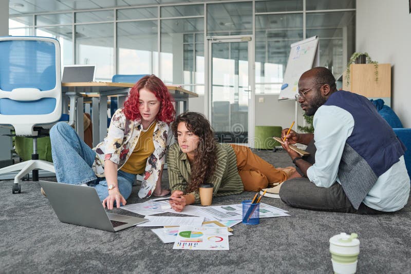 Group of Employees Gathered in Front of Laptop Discussing Data at ...