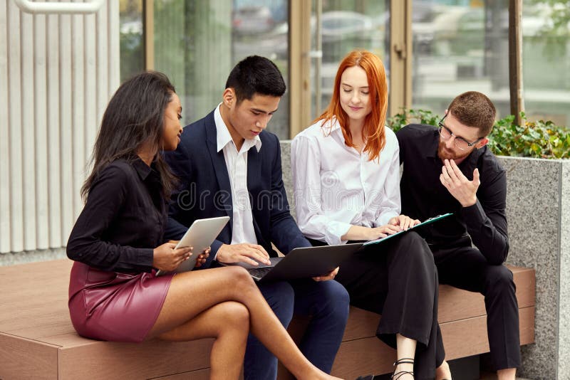 Group of Employees, Project Leader Sitting on Street and Working on ...