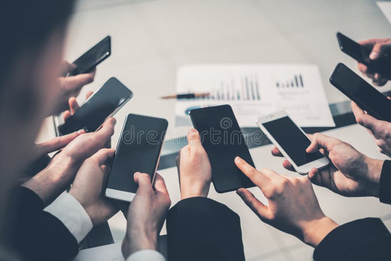 Group of Employees Using Their Smartphones in the Workplace Stock Photo ...