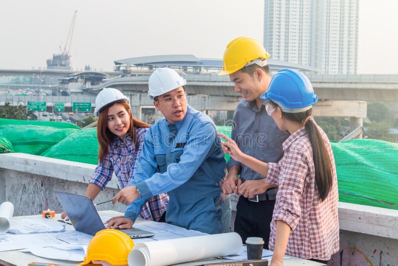 Group of Engineer Checking the Blueprint with Laptap and Talking about ...