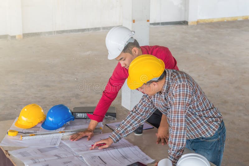 Group of Engineer Checking the Blueprint on the Table and Talking about ...