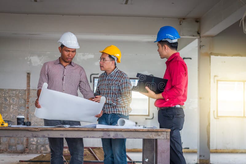 Group of Engineer Checking the Blueprint on the Table and Talking about ...