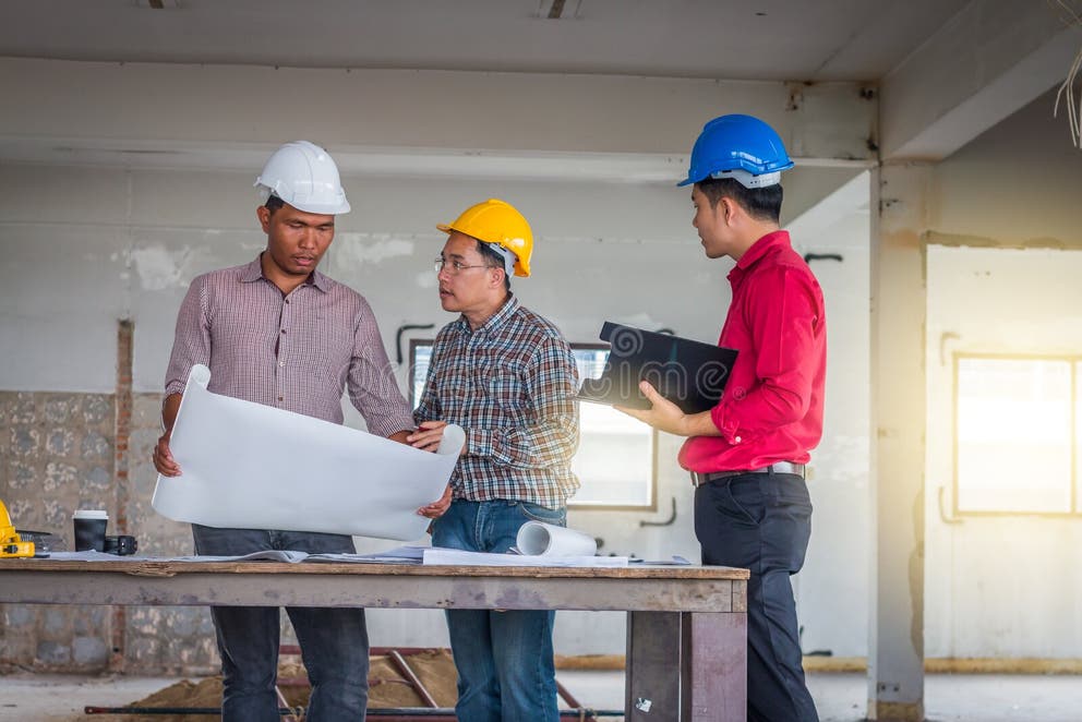 Group of Engineer Checking the Blueprint on the Table and Talking about ...