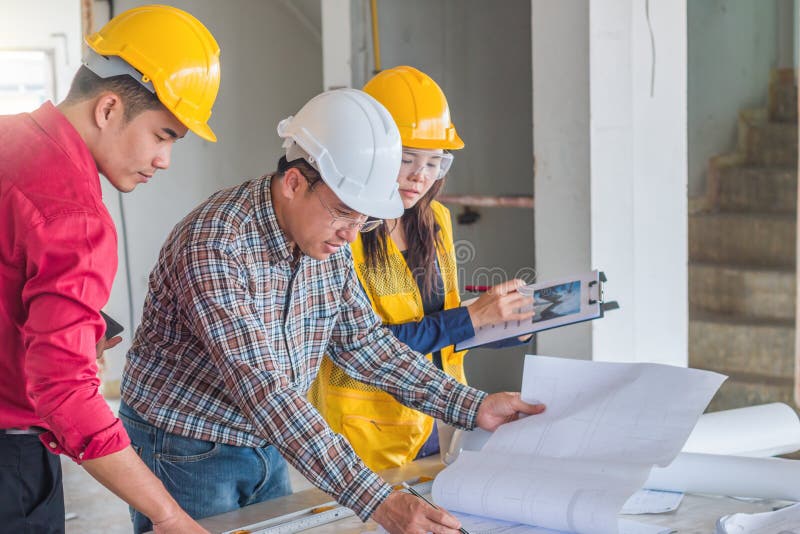 Group of Engineer Checking the Blueprint on the Table and Talking about ...