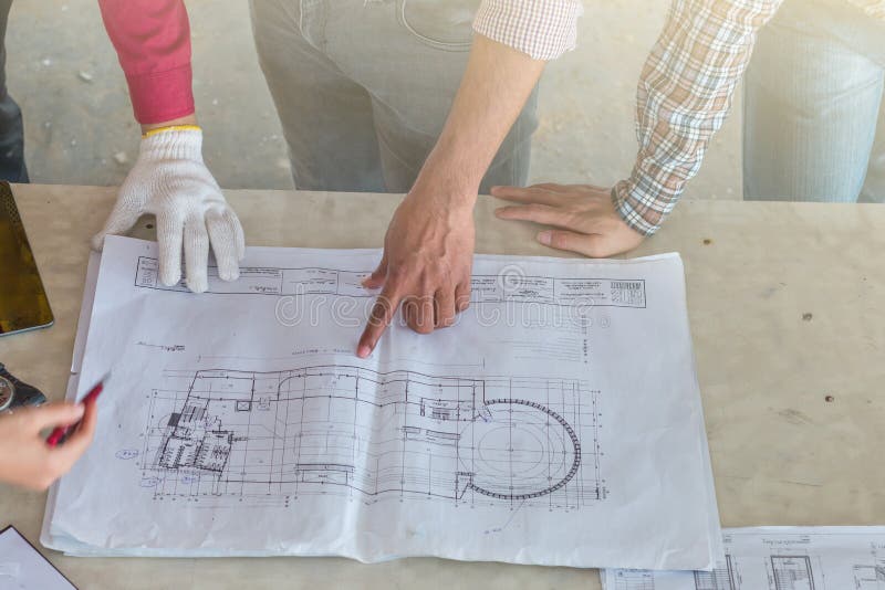 Group of Engineer Checking the Blueprint on the Table and Talking about ...