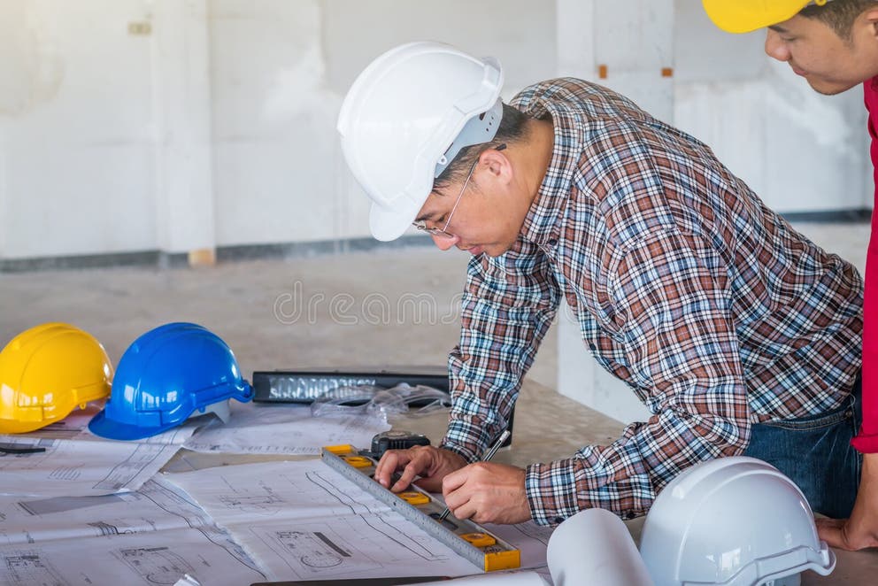 Group of Engineer Checking the Blueprint on the Table and Talking about ...