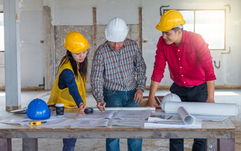 Group of Engineer Checking the Blueprint on the Table and Talking about ...