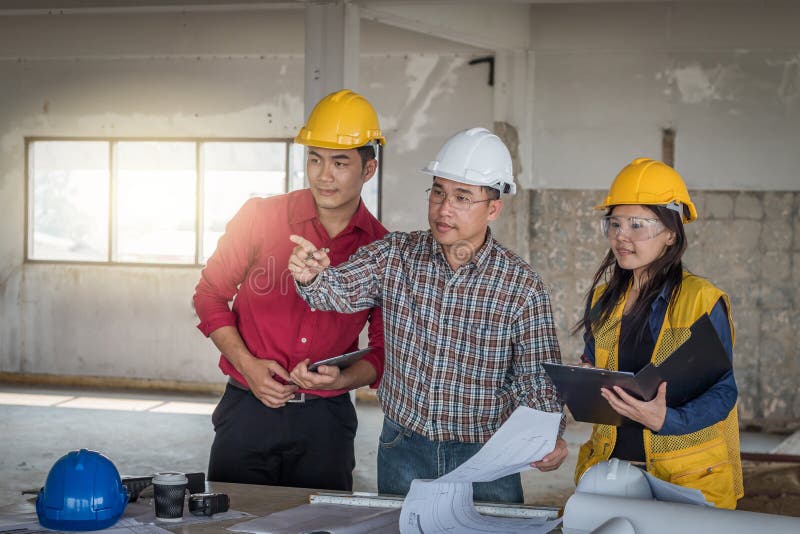 Group of Engineer Checking the Blueprint on the Table and Talking about ...