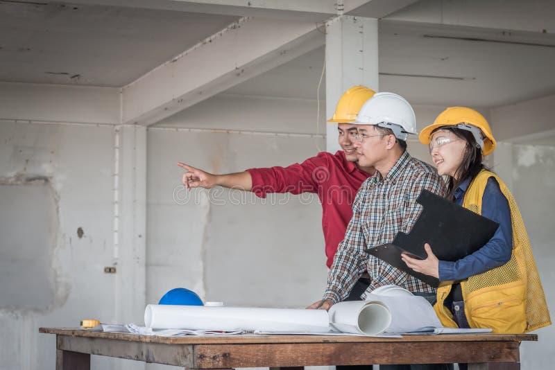 Group of Engineer Checking the Blueprint on the Table and Talking about ...