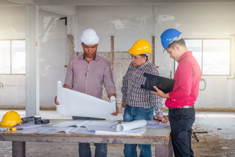 Group of Engineer Checking the Blueprint with Laptap and Talking about ...