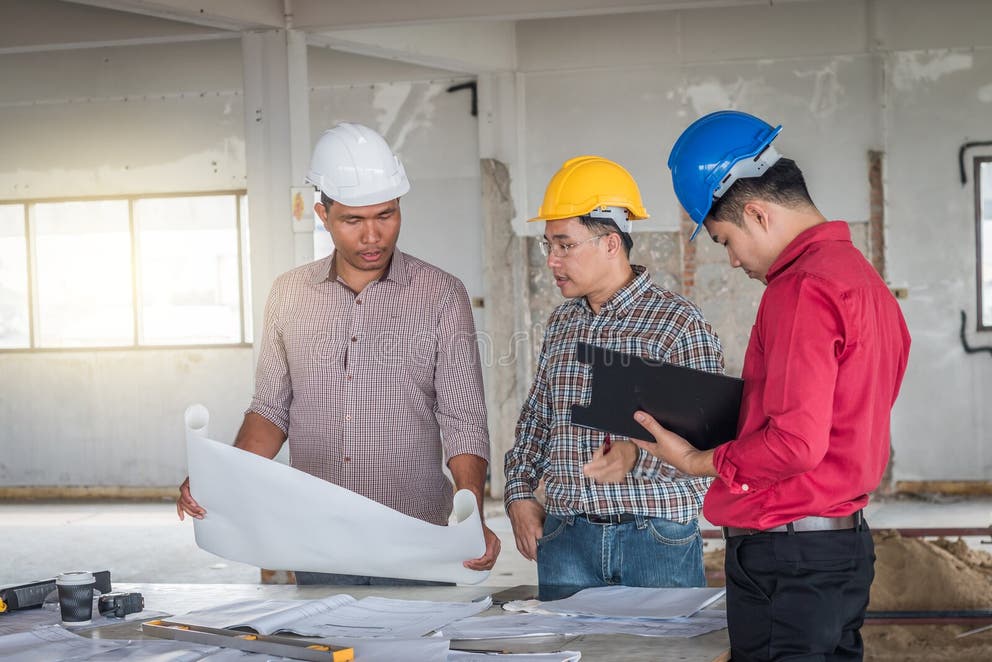 Group of Engineer Checking the Blueprint on the Table and Talking about ...