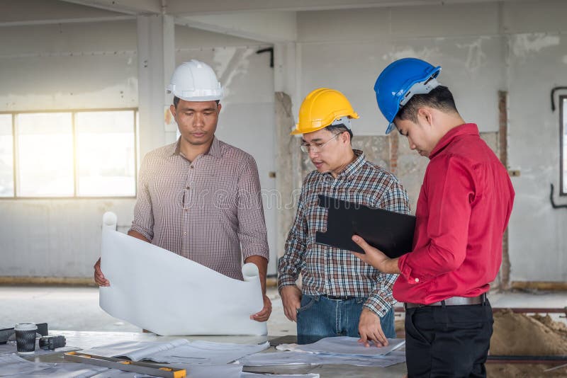Group of Engineer Checking the Blueprint on the Table and Talking about ...