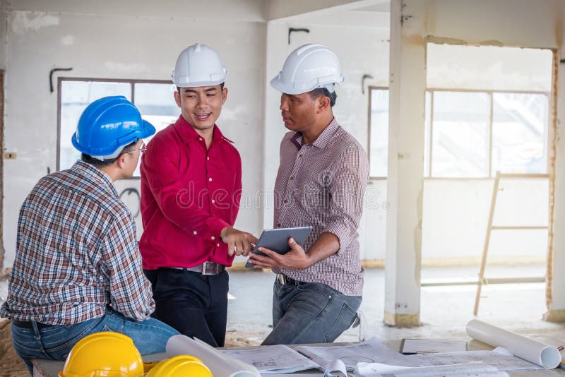 Group of Engineer Checking a Job on Tablet and Talking about ...