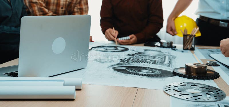 Team of Engineers Collaborating on Mechanical Designs with Laptop and ...