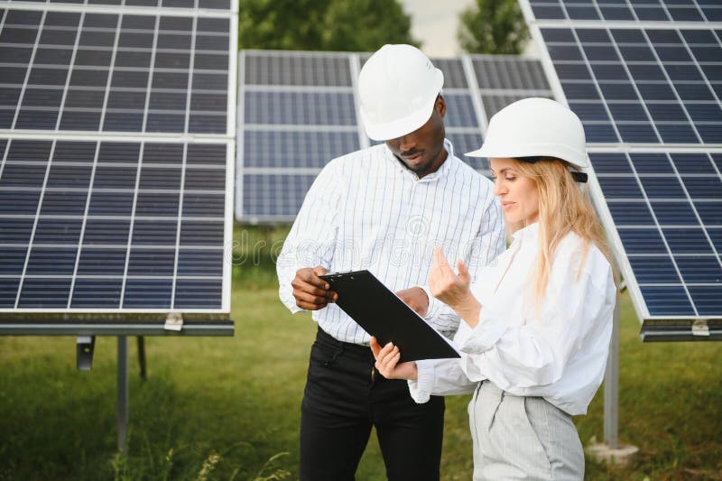 A Group of Engineers Work on a Solar Panel Farm. Stock Photo - Image of ...