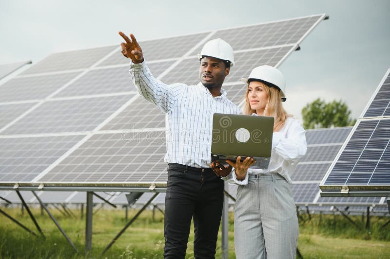 A Group of Engineers Work on a Solar Panel Farm. Stock Image - Image of ...