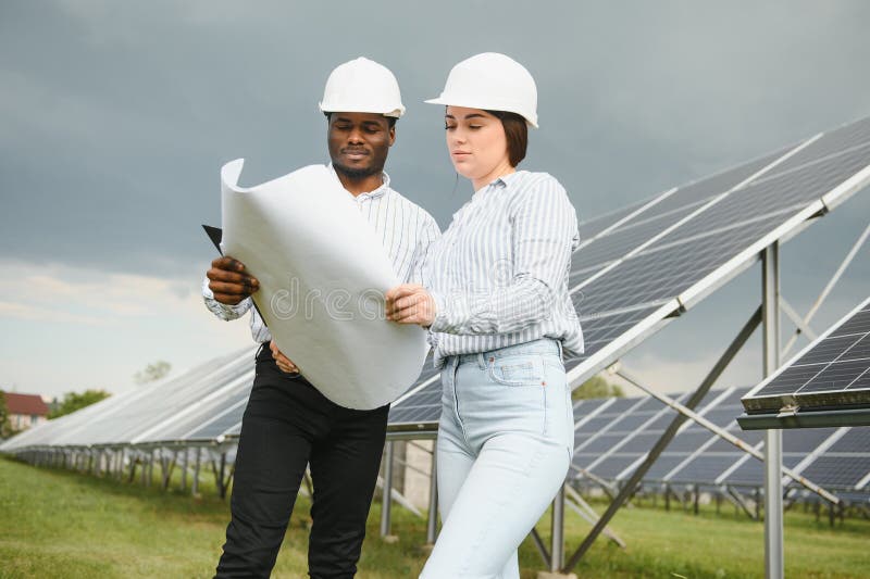 A Group of Engineers Work on a Solar Panel Farm. Stock Image - Image of ...