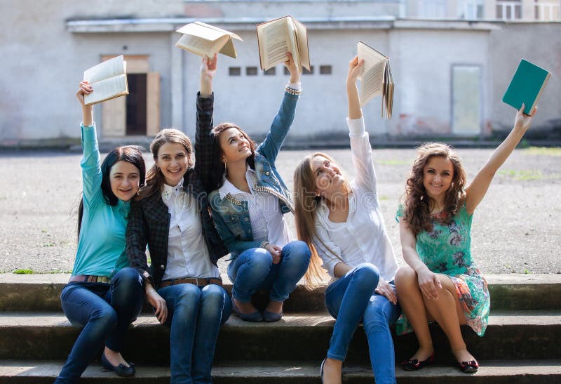 A Group of Female Students Sitting with Books in the Courtyard of the ...