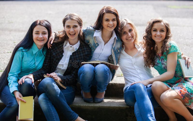 A Group of Female Students Sitting with Books in the Courtyard of the ...