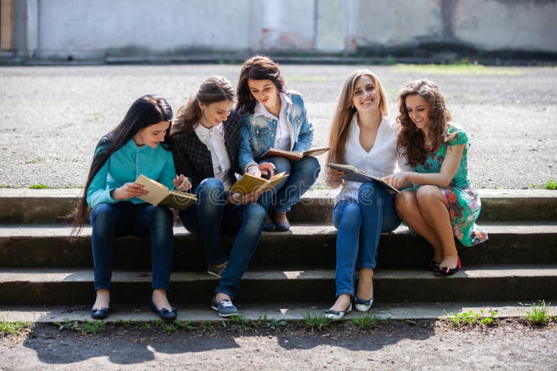 A Group of Female Students Sitting with Books in the Courtyard of the ...