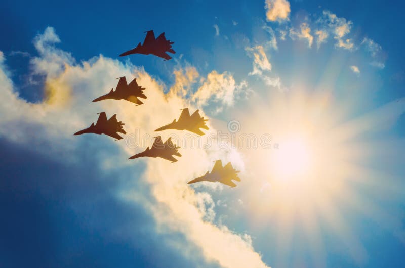 Group of Fighter Airplanes Fly with the Bright Sun in the Sky Stock ...