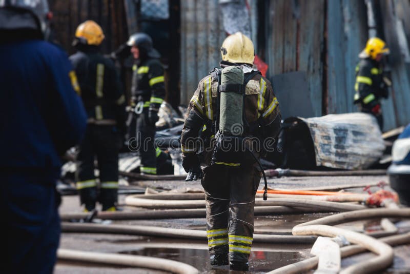 Group of Fire Men in Protective Uniform during Fire Fighting Operation ...