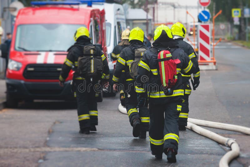 Group of Fire Men in Protective Uniform during Fire Fighting Operation ...