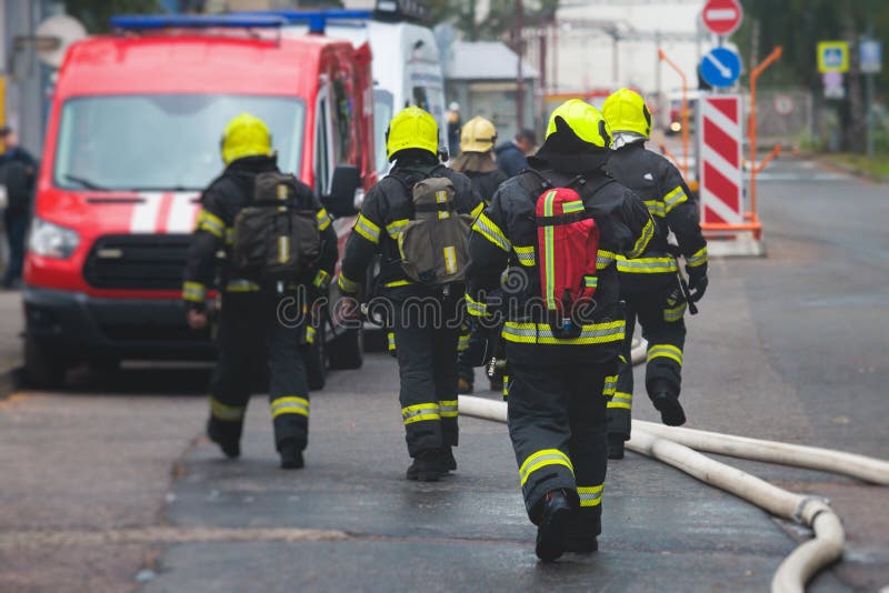 Group of Fire Men in Protective Uniform during Fire Fighting Operation ...