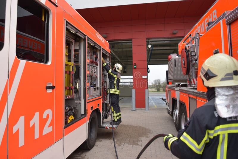 Group of Firefighters at the Emergency Vehicle in the Fire Station ...