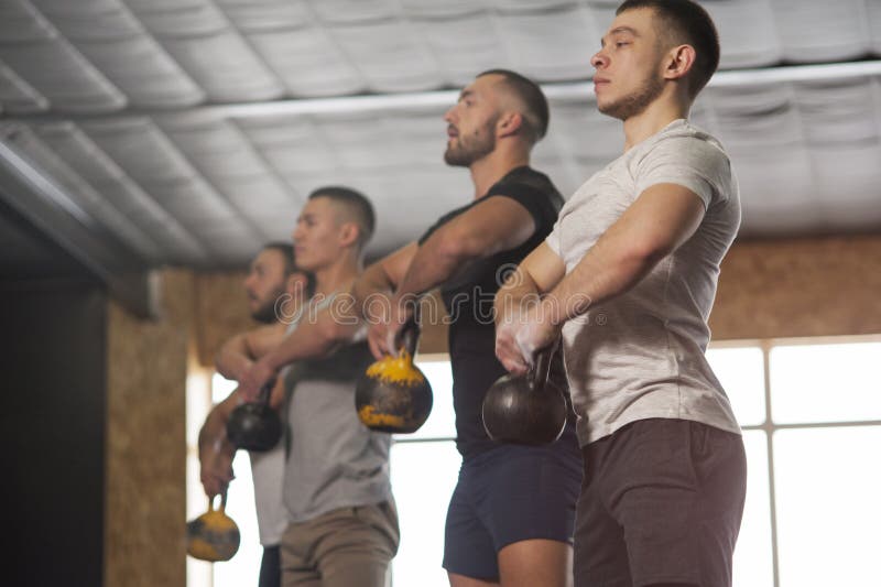 Group of Fit and Focused Men Training with Kettlebells. Stock Photo ...