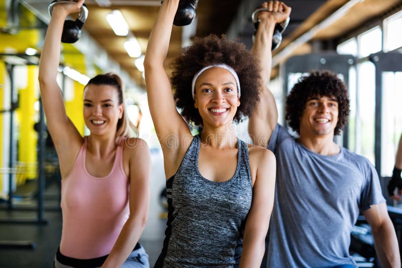 Group of Fit People Lifting Dumbbells during an Exercise Class at the ...