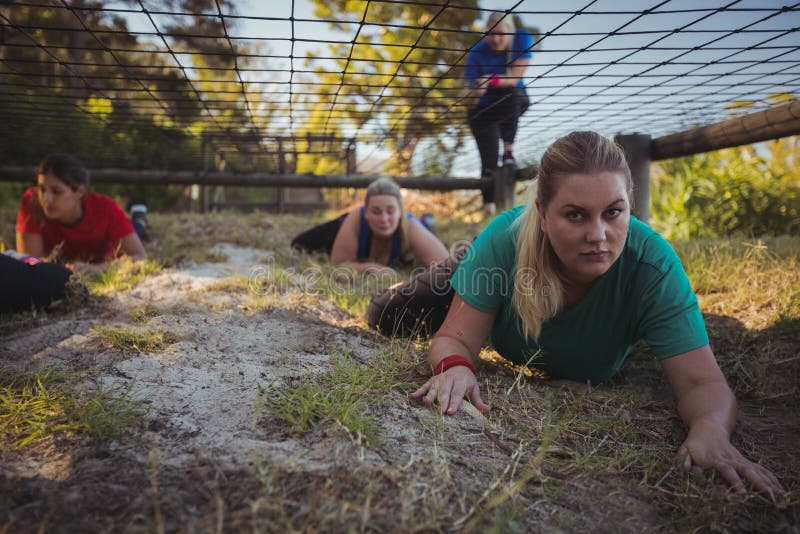 Group of Fit Women Crawling Under the Net during Obstacle Course ...
