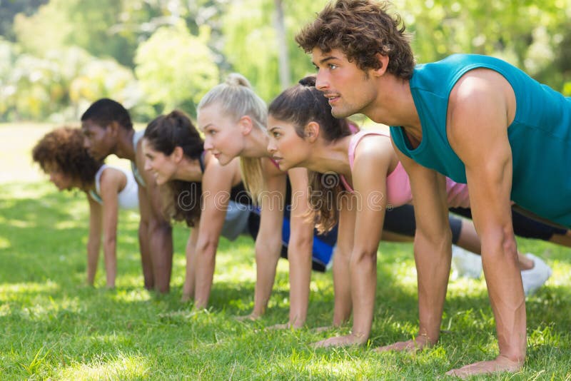Group of Fitness People Doing Push Ups in Park Stock Photo - Image of ...