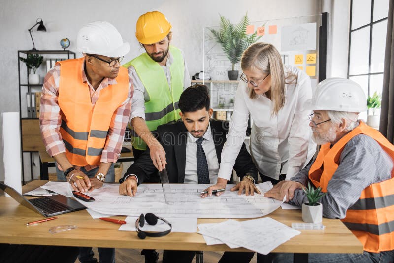 Group of Five Multiracial People in Suits and Helmets Brainstorming for ...