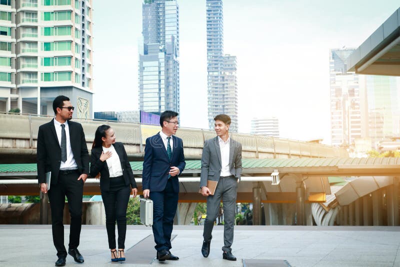 A Group of Four Asian Businessmen Standing Meeting for Discussions on ... A Group of Four Asian Businessmen Standing Meeting for Discussions on ...