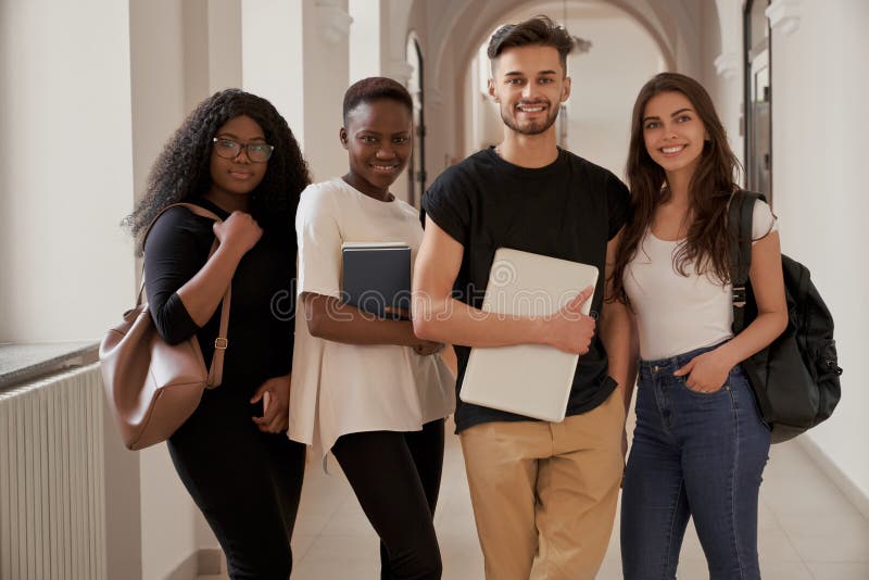 Four Mixed-race Students Looking at Camera in College Hall Stock Photo ...