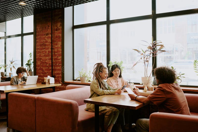 Collaborating in Cozy Modern Cafe Setting by Window Stock Image - Image ...