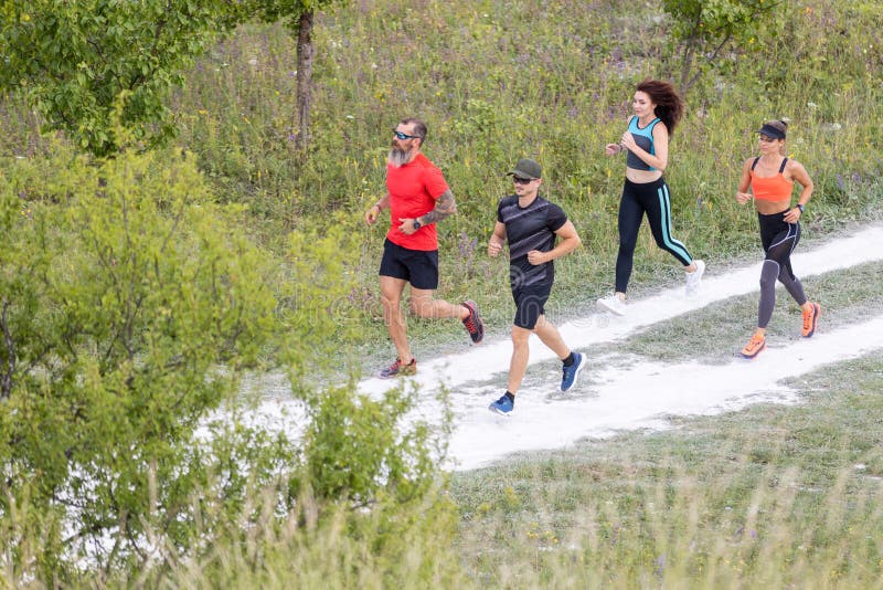 Group of Four Young People Run on the Country Road Stock Photo - Image ...
