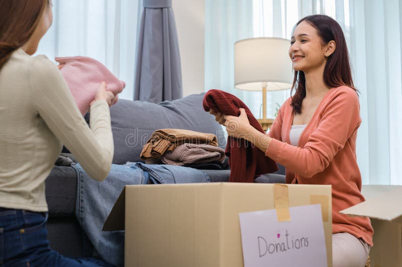 Group of Friend Sorting and Packing Clothes into a Donation Box ...