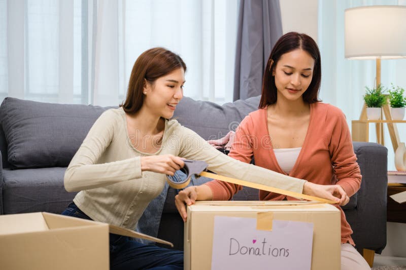 Group of Friend Sorting and Packing Clothes into a Donation Box ...