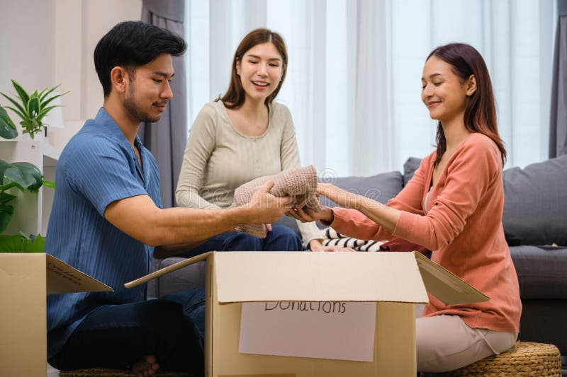 Group of Friend Sorting and Packing Clothes into a Donation Box.community Support, and ...