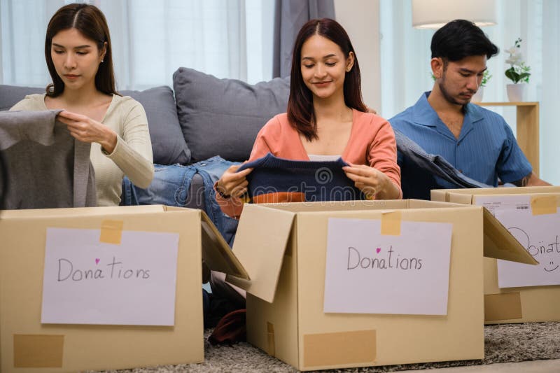 Group of Friend Sorting and Packing Clothes into a Donation Box ...