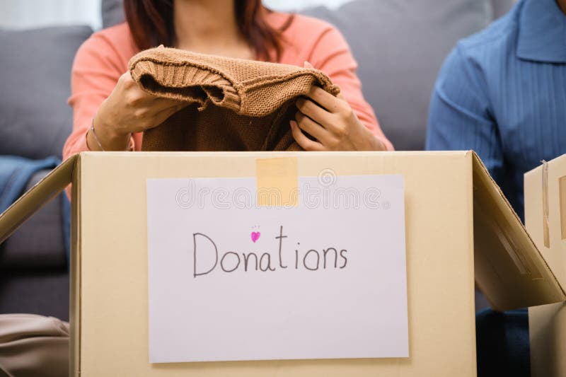 Group of Friend Sorting and Packing Clothes into a Donation Box ...