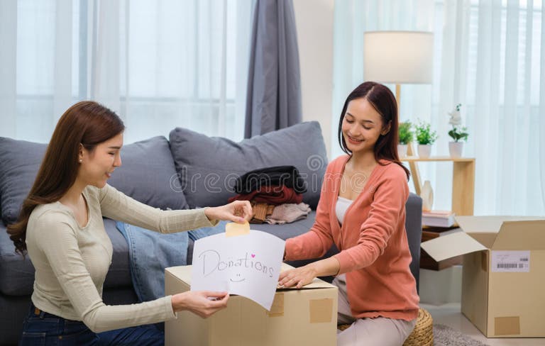 Group of Friend Sorting and Packing Clothes into a Donation Box ...