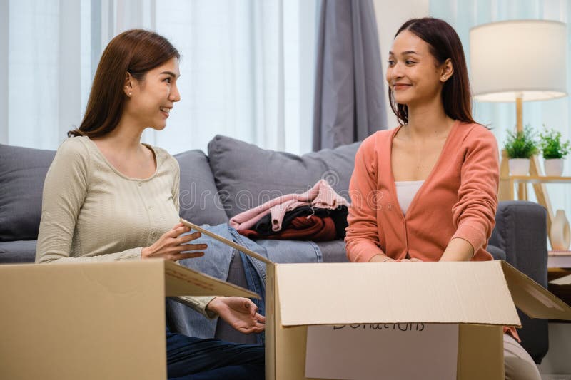 Group of Friend Sorting and Packing Clothes into a Donation Box ...