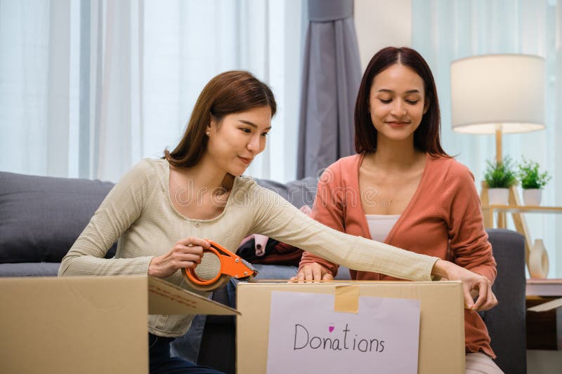 Group of Friend Sorting and Packing Clothes into a Donation Box ...