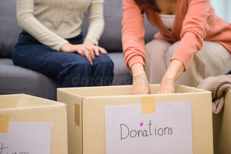 Group of Friend Sorting and Packing Clothes into a Donation Box ...