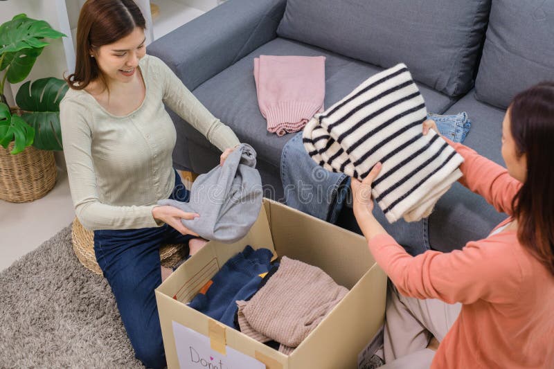 Group of Friend Sorting and Packing Clothes into a Donation Box.community Support, and ...